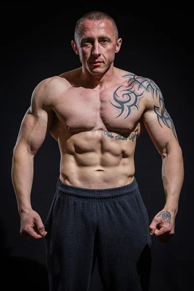 Muscle man in tattoos with dumbbells — Stock Photo © aallm #44346111