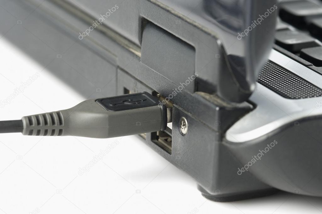 Cable USB conectado al puerto USB de un portátil 2023