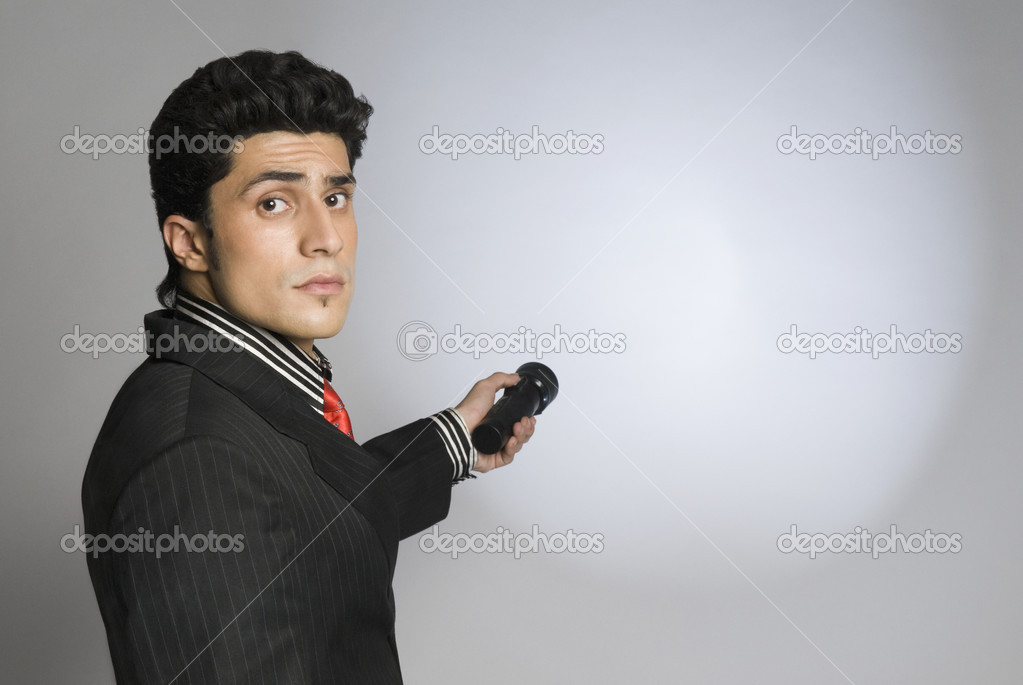 Businessman holding a flashlight Stock Photo by ©imagedb_seller 33034441