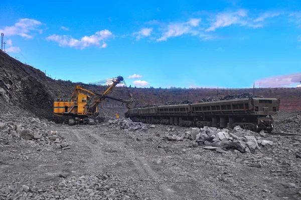 Excavator loads iron ore into wagons. Iron ore mining - Stock Image ...