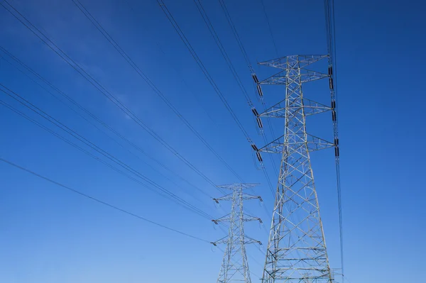 High voltage electric power line pylon against blue sky - Stock Image ...
