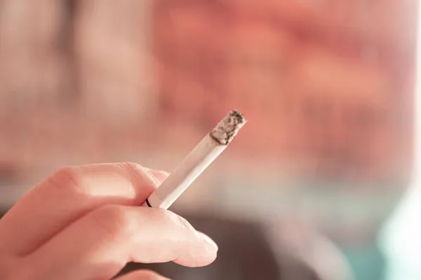 Una Persona Fumando Cigarrillo Sobre Fondo Borroso — Foto de stock ...