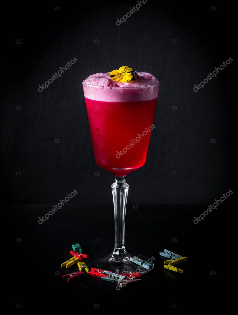 Una toma vertical de una copa de cóctel con flores y pequeños pinzas ...