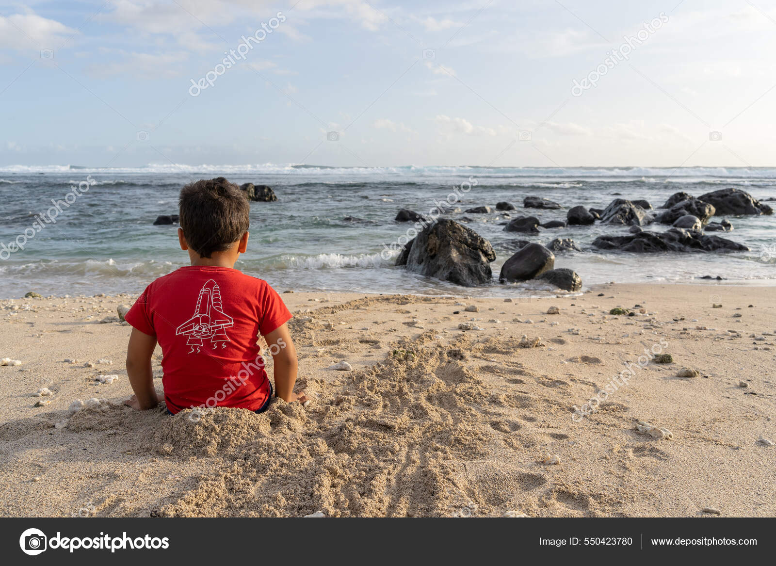 Boy Sitting Beach Looking Sea Stock Photo by ©Wirestock 550423780