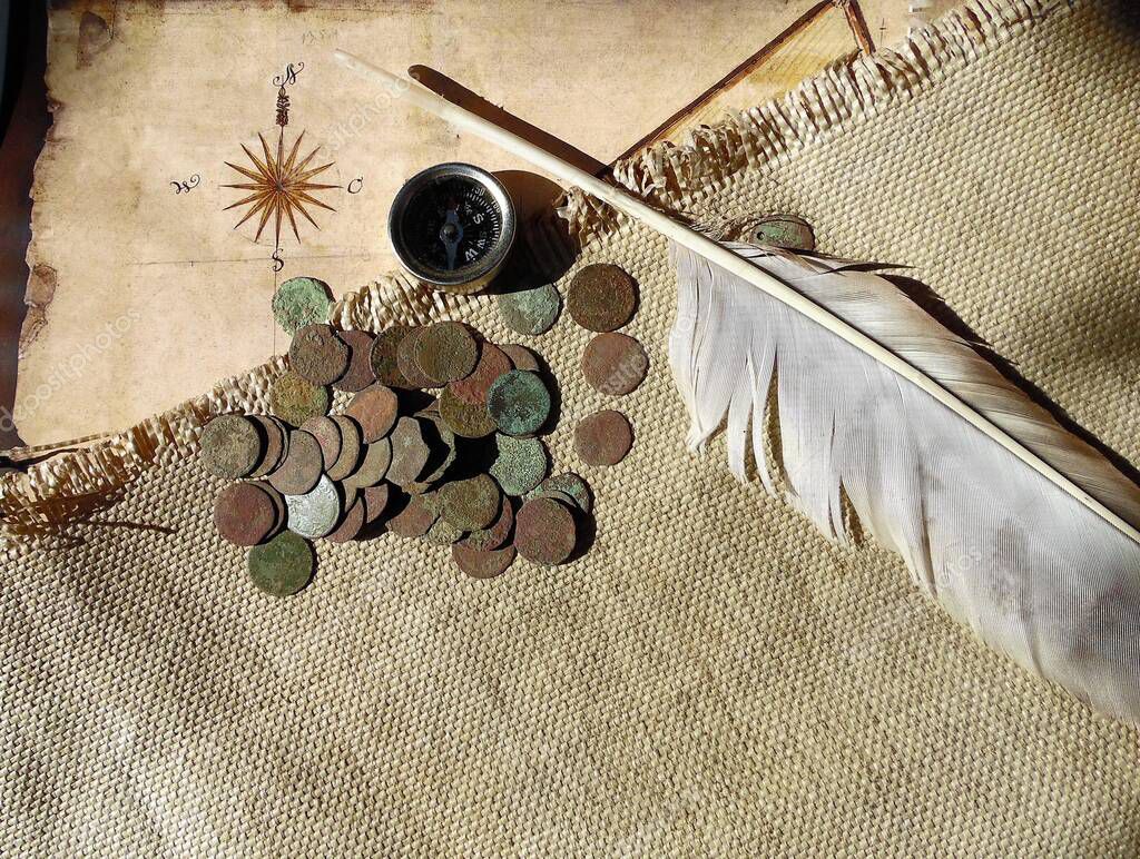 antique copper coins and an eagle feather against the background of an ...