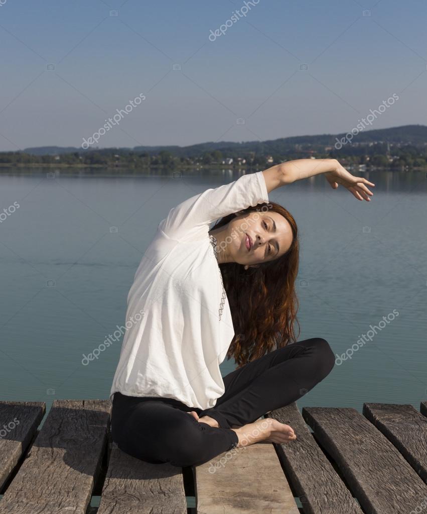 Woman doing seated side bend during yoga outdoors — Stock Photo ...