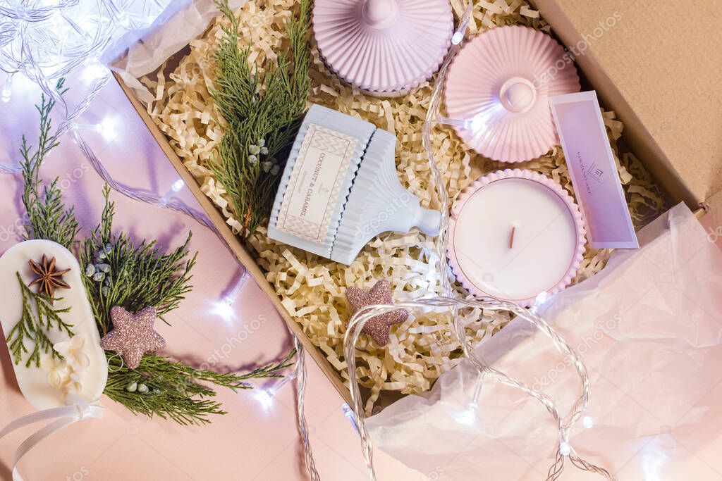 Una caja de copas de velas en colores pastel con ramas de enebro ...