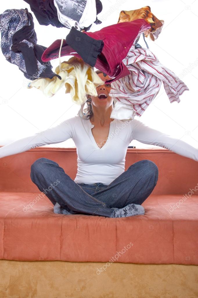 Girl sitting and throwing clothes in the air — Stock Photo ...