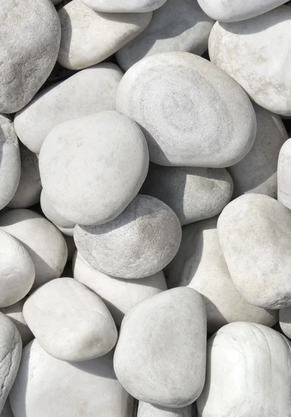 Pile of white stone, pebble, rock for background or texture Close-up of ...