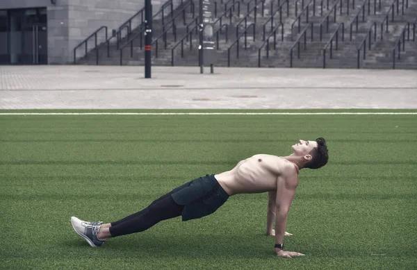 Sporty Man Making back Plank Exercise. guy in reverse plank exercise ...