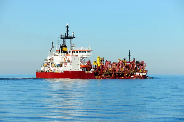 Cargo container ship and small cargo ship sailing in still water ...