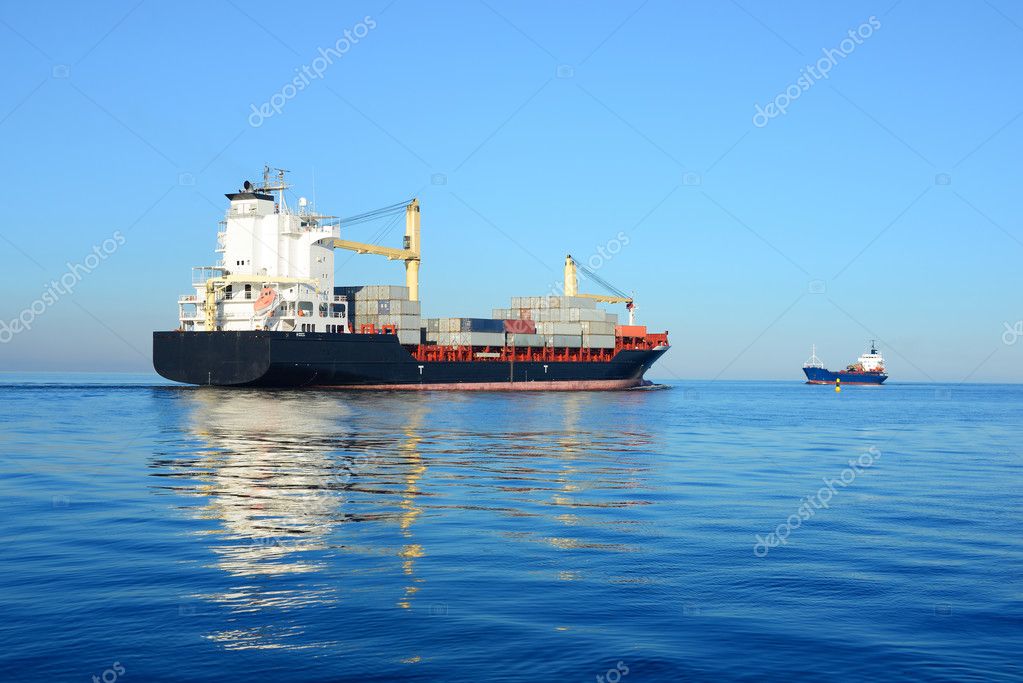Cargo container ship and small cargo ship sailing in still water ...