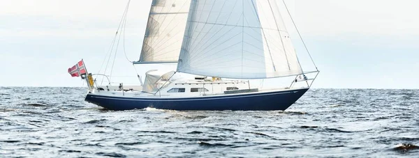Blue sloop rigged yacht sailing in an open Baltic sea on a clear day ...