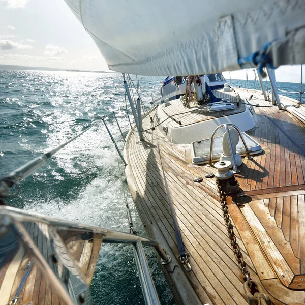 Sloop-rigged modern yacht with wooden teak deck sailing on a clear day ...
