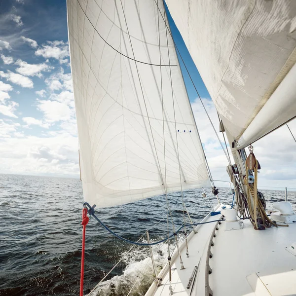 White sloop rigged yacht sailing in an open sea on a clear day. A view ...