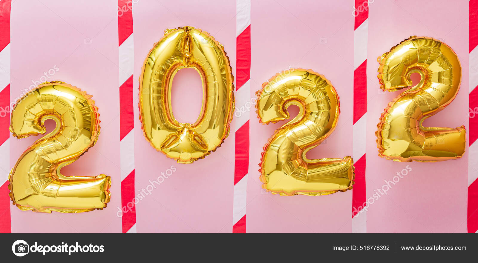 2022 gold balloons. 2022 in line with warning tape on pink background ...