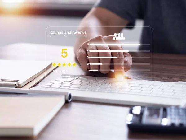 Man sending ratings and reviews with 5-star online on computer keyboard ...