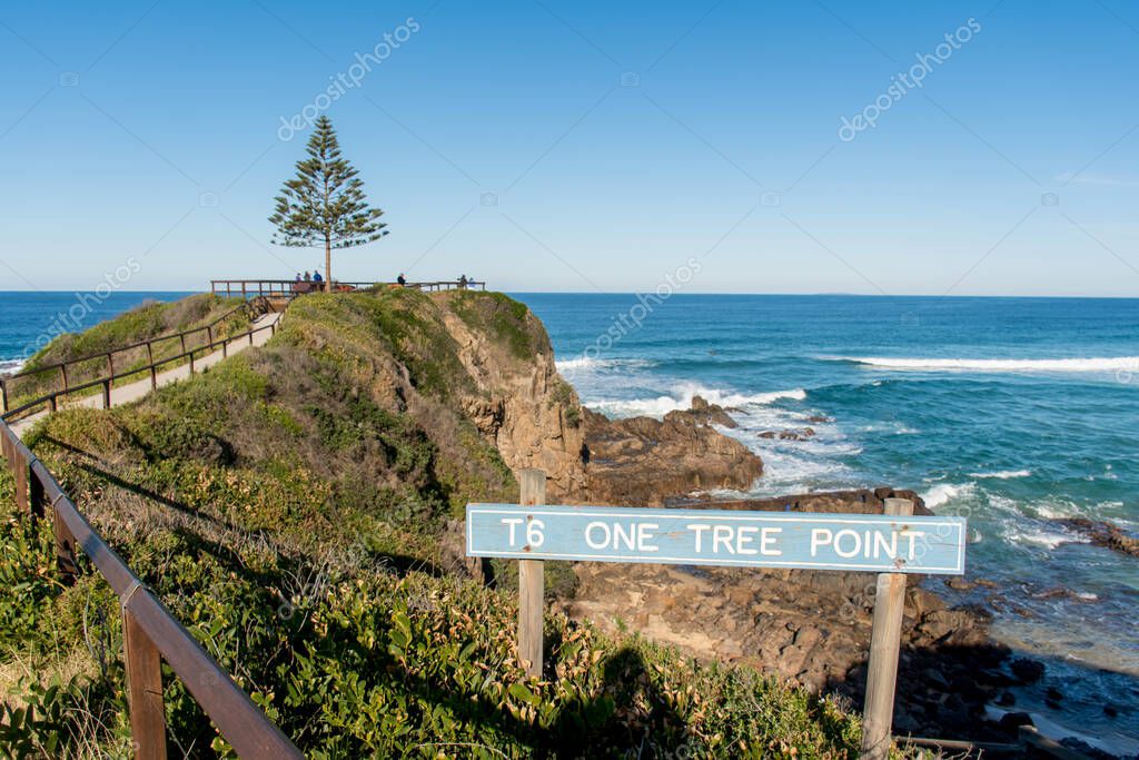 Ondas oceánicas con espuma blanca y letrero de vigilancia de One Tree ...