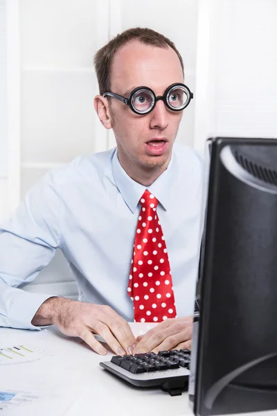 Shocked and stressed business man with lenses and a red tie at desk ...