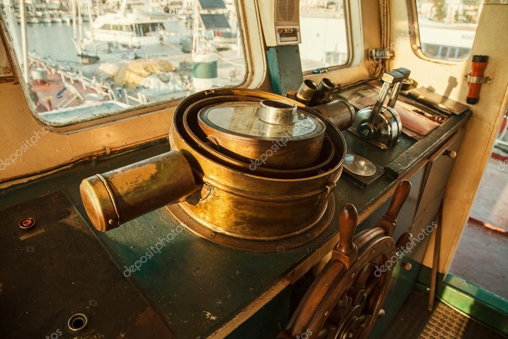 Old ancient steering wheel of copper in the cockpit of an old an ...