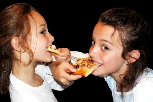 Two girls eating meat pie - Stock Image - Everypixel