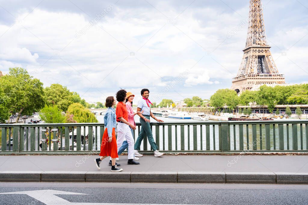 Grupo de jóvenes amigos felices que visitan París y la Torre Eiffel, la ...