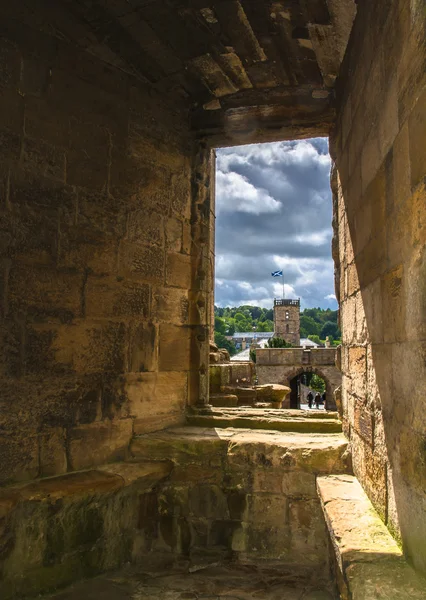 View through arched castle window to sunset coastal landscape, cornwall ...