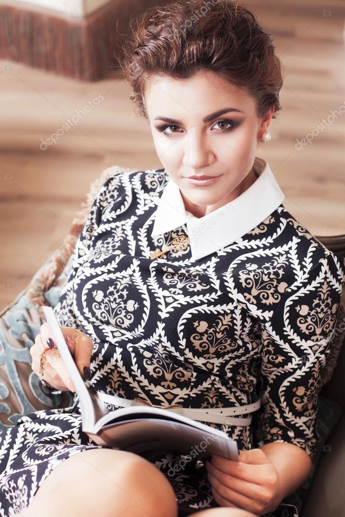 Beautiful Brunette Rich Saucy Woman In Elegant Dress Sitting On A Chair In A Room With Classic