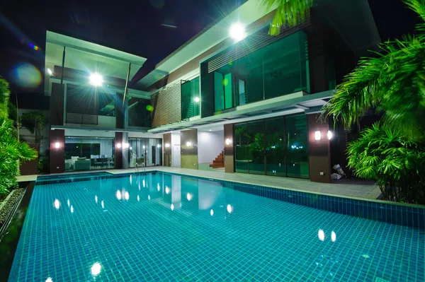 Modern house with swimming pool at night - Stock Image - Everypixel