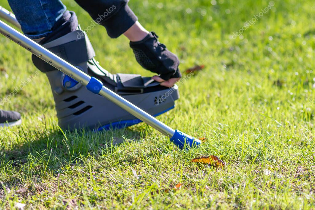 Niño con pie roto y zapato ortopédico o caminante después de fractura ...