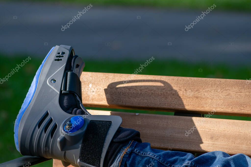 Niño con pie roto y zapato ortopédico o caminante después de fractura ...