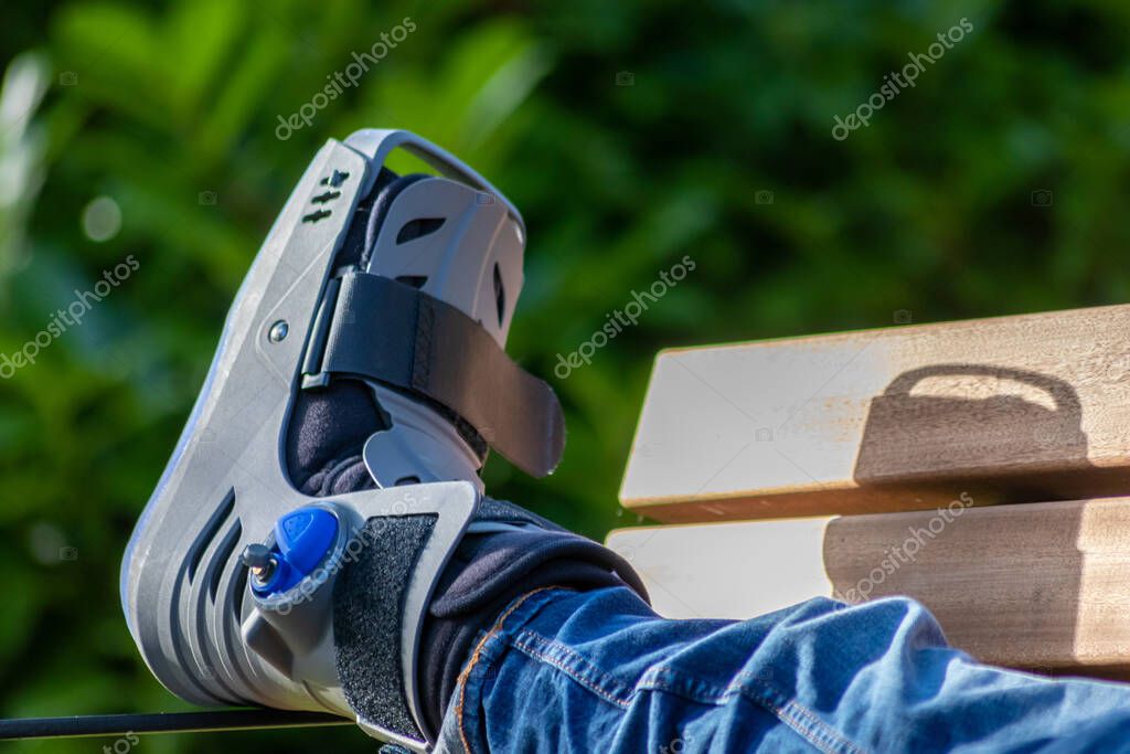 Niño con pie roto y zapato ortopédico o caminante después de fractura ...