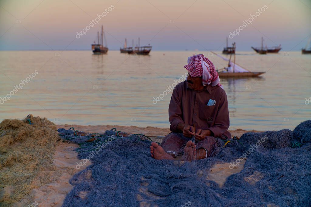 Un artesano árabe tradicional tejiendo redecilla en Katara pueblo ...