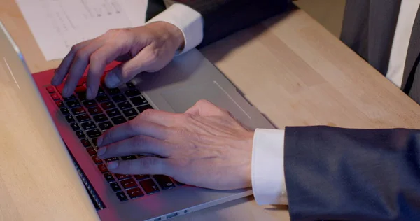 Close-up man hands typing text on laptop keyboard. He makes an email ...