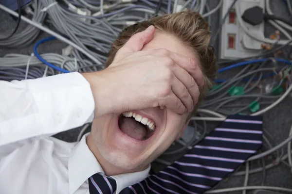 Frustrated man surrounded by computer cables - Stock Image - Everypixel