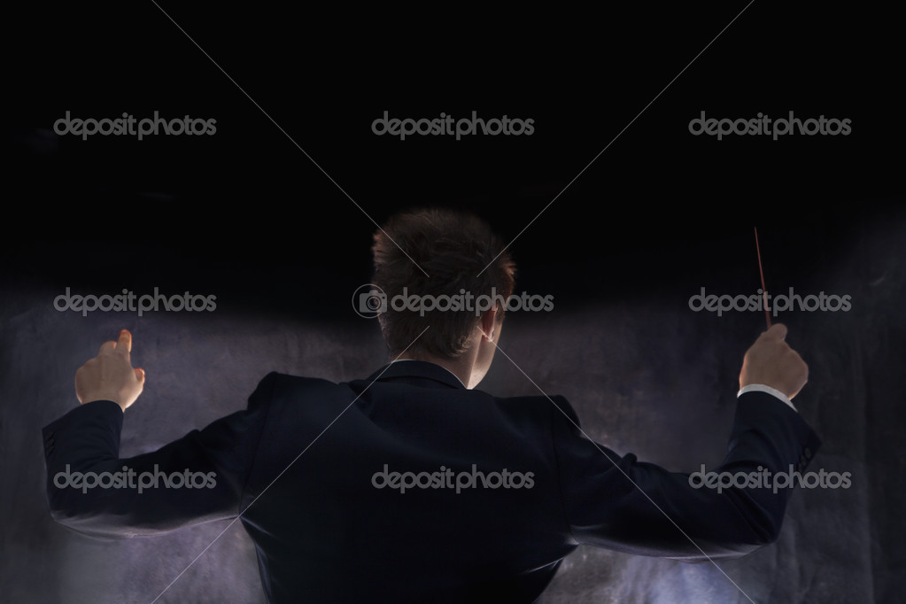 Conductor with baton raised at a performance — Stock Photo © XiXinXing ...