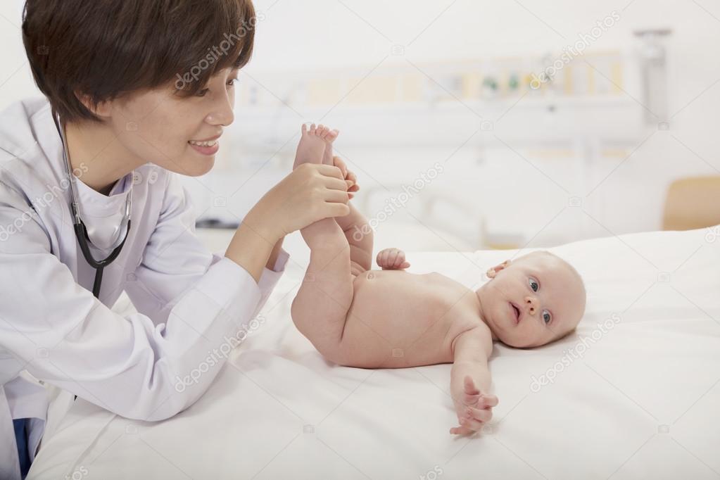 Doctor examining a baby in the doctors office — Stock Photo © XiXinXing ...