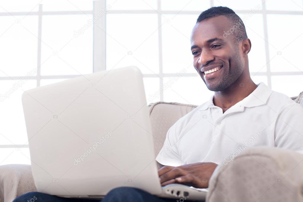 African man using computer and smiling Stock Photo by ©gstockstudio ...