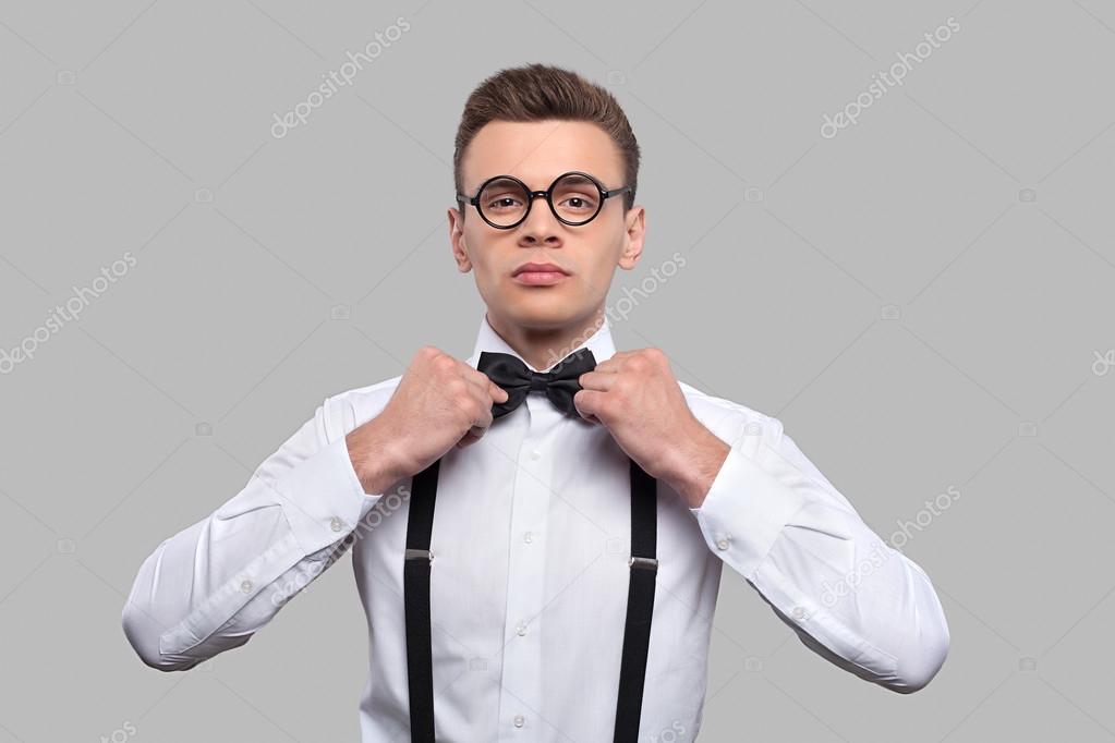 Serious young nerd man adjusting his bow tie Stock Photo by ...