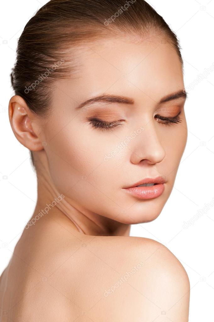 Side view of beautiful young shirtless woman looking at her shoulder ...