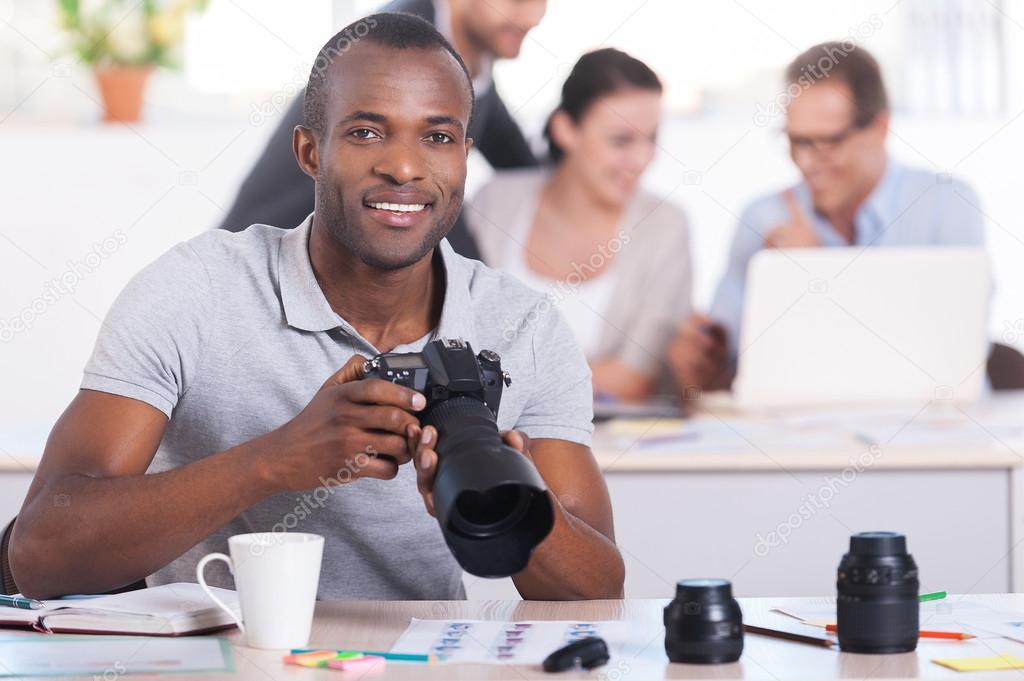 African man holding camera and smiling Stock Photo by ©gstockstudio ...