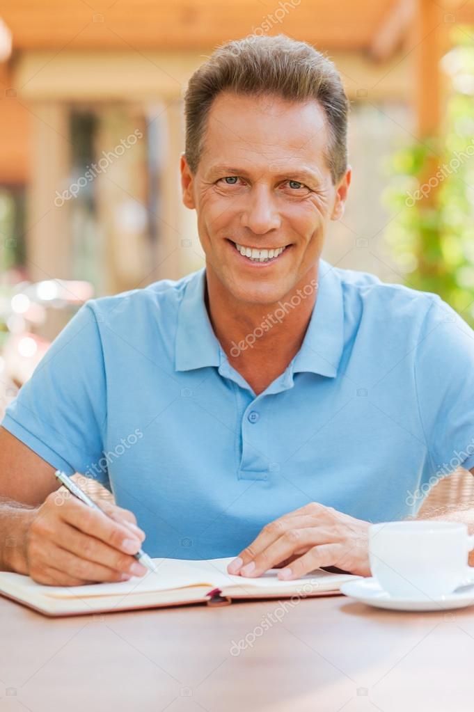 Man writing something in his note pad outdoors Stock Photo by ...