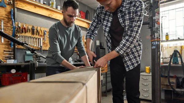 Male workers opening cardboard box with bicycle - Stock Image - Everypixel