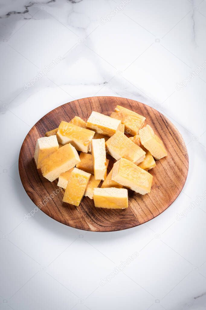 Tamago servido en plato de madera sobre fondo de mesa blanco. Tortilla ...