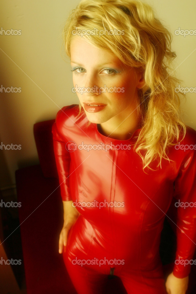 Hermosa mujer vestida de rojo que se pone en el sofá — Foto de stock ... Hermosa mujer vestida de rojo que se pone en el sofá — Foto de stock ...