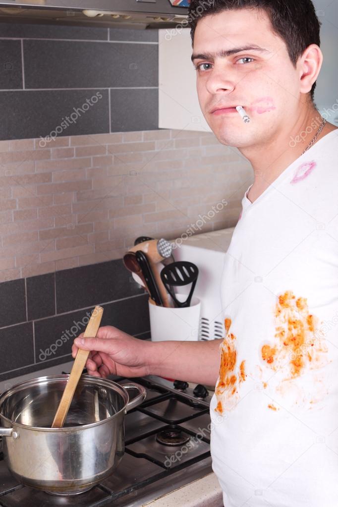 Handsome young man cooking and smoking — Stock Photo © olgamarc #42423061