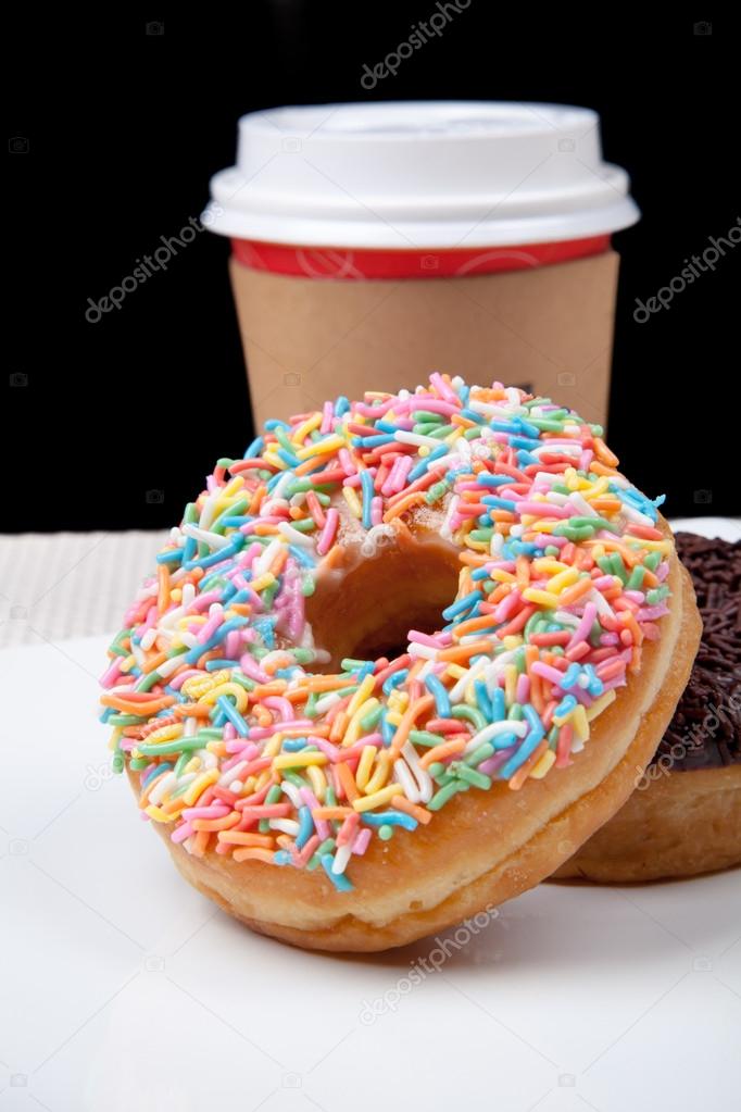 Colorido donas y café en el plato blanco con fondo negro — Foto de ...