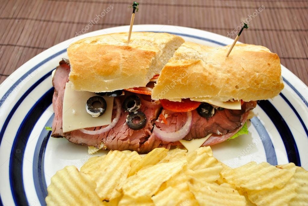 Sándwich de carne y verduras servido con patatas fritas 2024