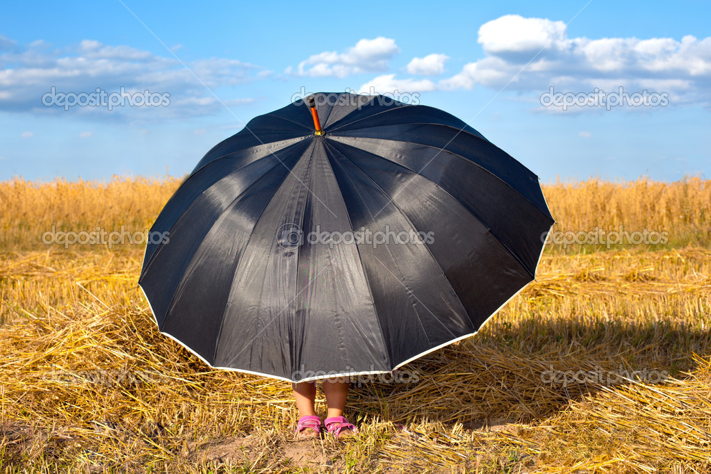 Little girl hiding under big black umbrella in fair weather Stock Photo ...