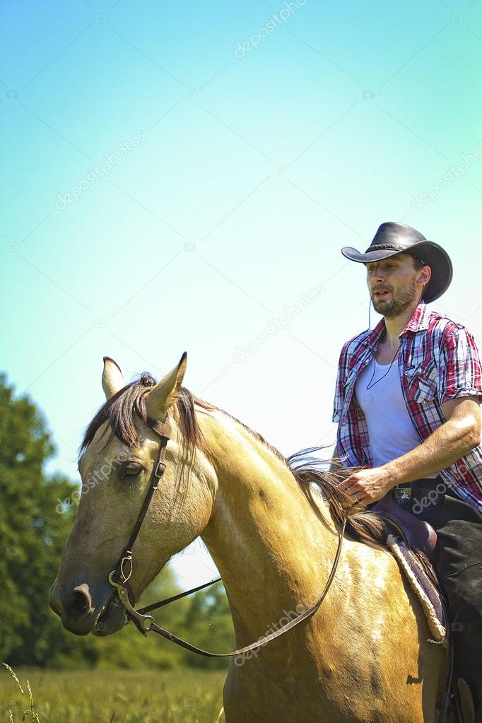 Young cowboy man ridig with horse — Stock Photo © Carmelka #49264809